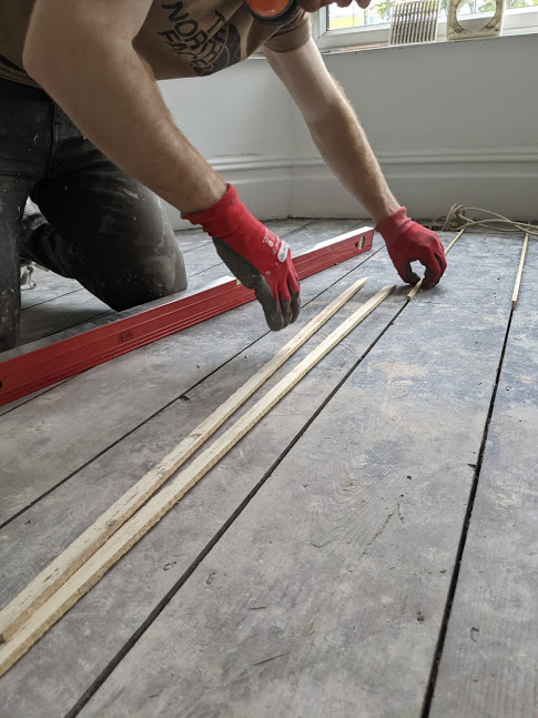 Filling between wooden floorboards with slivers - it's a fixer upper